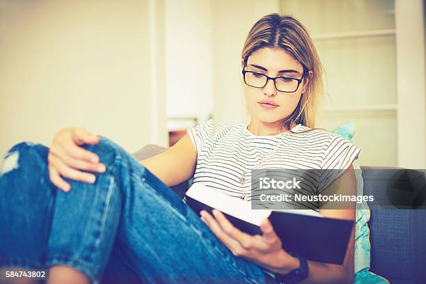 Wanita Cantik Membaca Buku Sambil Duduk Di Sofa Foto Stok Unduh