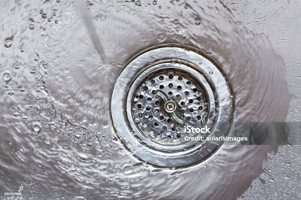 Water Flowing Going Down Drain In Stainless Steel Kitchen Sink Stock