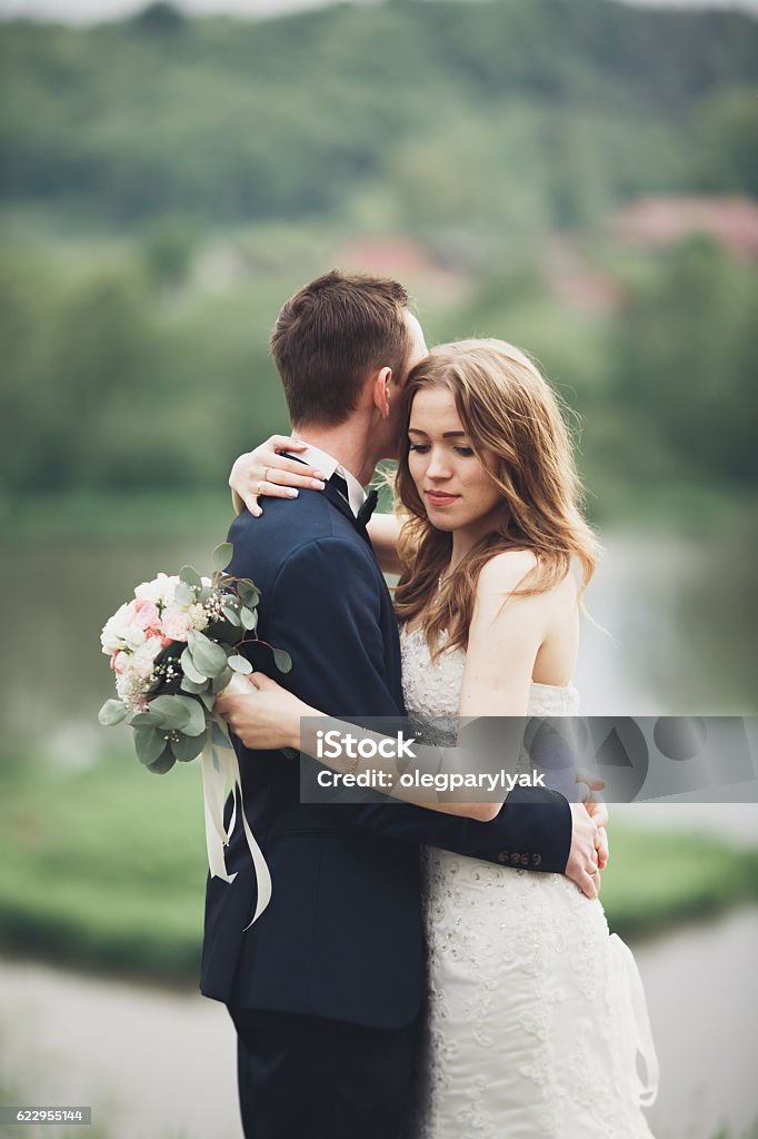 Beautifull Wedding Couple Kissing And Embracing Near Lake With Island
