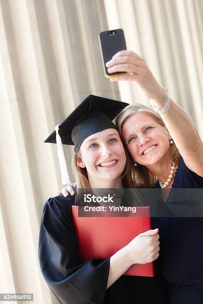 Happy Mother Congratulating Hugging Daughter In University Graduation
