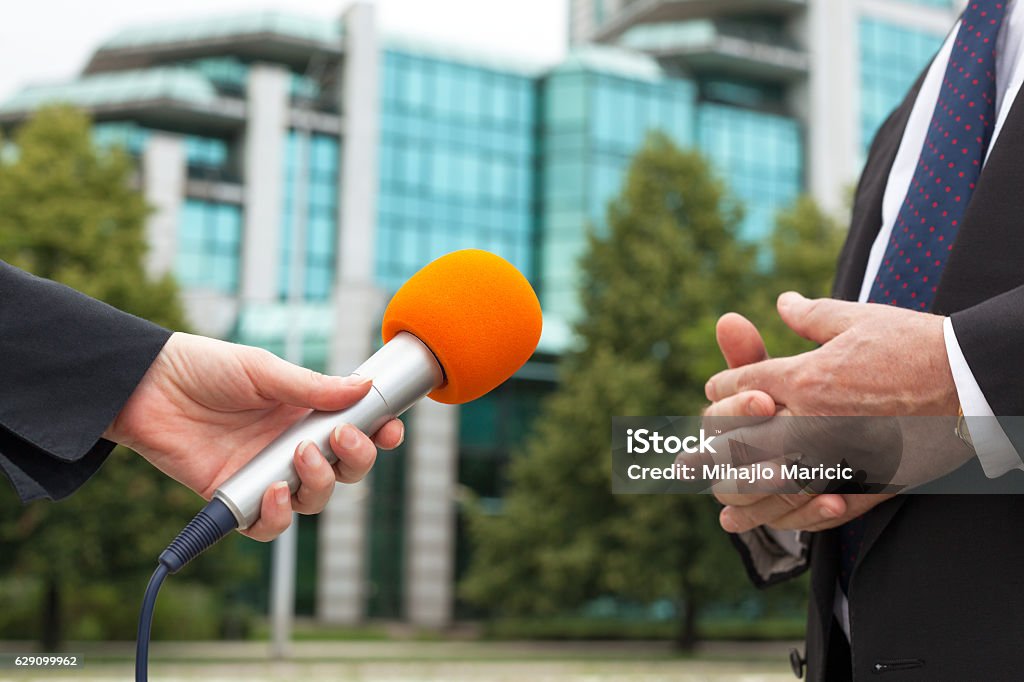 Reportero Sosteniendo Un Micrófono Entrevistando A Empresario O