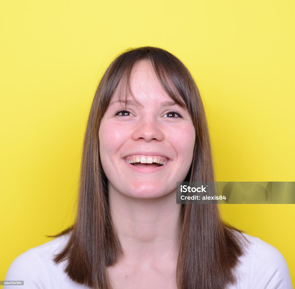 Portrait Of Beautiful Young Woman Smiling Against Yellow Background