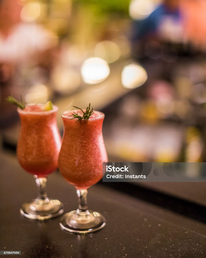 Two Fresh Strawberry Daiquiris Decorated With A Sprig Of Thyme And A