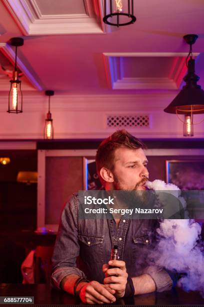 Vape입니다 증기의 구름에서 Vaping 남자입니다 사진은 Vape 바에 갈색 머리에 대한 스톡 사진 및 기타 이미지 갈색