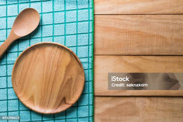 Piring Kayu Kosong Dan Sendok Di Atas Meja Kayu Dengan Taplak Meja