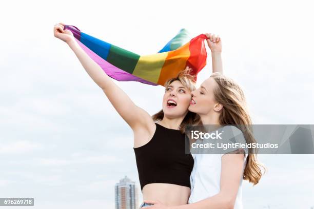 Feliz Pareja De Lesbianas Besándose Y Ondeando La Bandera Lgbt Al Aire