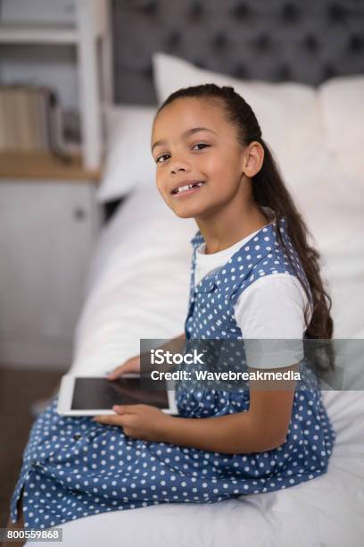 Gadis Tersenyum Memegang Tablet Digital Sambil Duduk Di Tempat Tidur Di