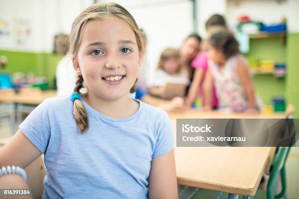 Porträt Von Glücklich Schulmädchen Im Klassenzimmer Sitzen Stockfoto