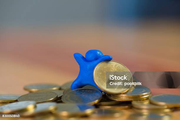 Miniatur Sosok Manusia Yang Terbuat Dari Plastikine Biru Dengan Koin Di