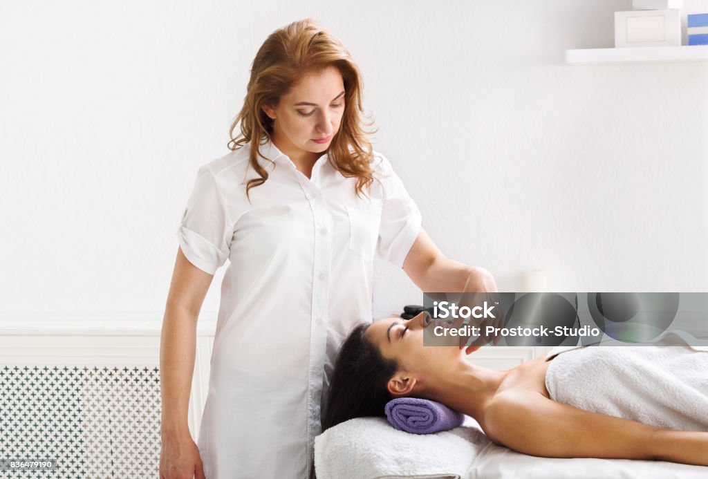 Woman Beautician Doctor Make Head Massage In Spa Wellness Center Stock