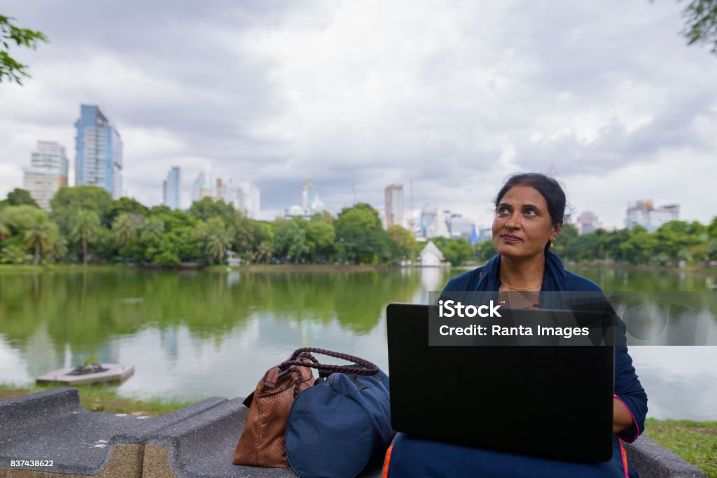 Portrait Of Mature Beautiful Indian Businesswoman Relaxing At Public
