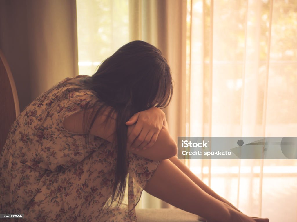 Depressed Woman Hug Her Knee And Cry While Sitting Alone On The Floor