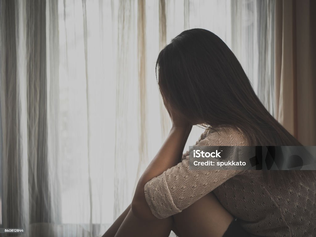 Sad Woman Hug Her Knee And Cry While Sitting Alone In A Empty Room