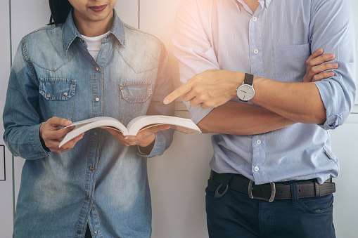 Siswa Muda Yang Ceria Berdiri Memegang Buku Dan Membaca Teman Sekelas ... Siswa Muda Yang Ceria Berdiri Memegang Buku Dan Membaca Teman Sekelas ...