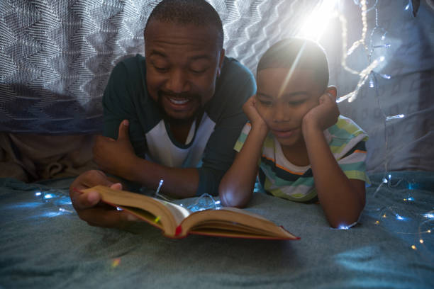 Free Stock Photo of Father and son reading book with flashlight ...
