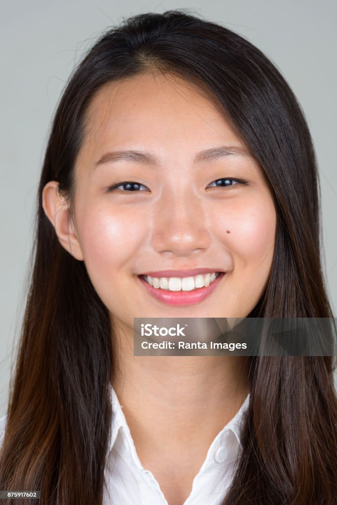 Young Beautiful Asian Woman Wearing White Shirt Against White