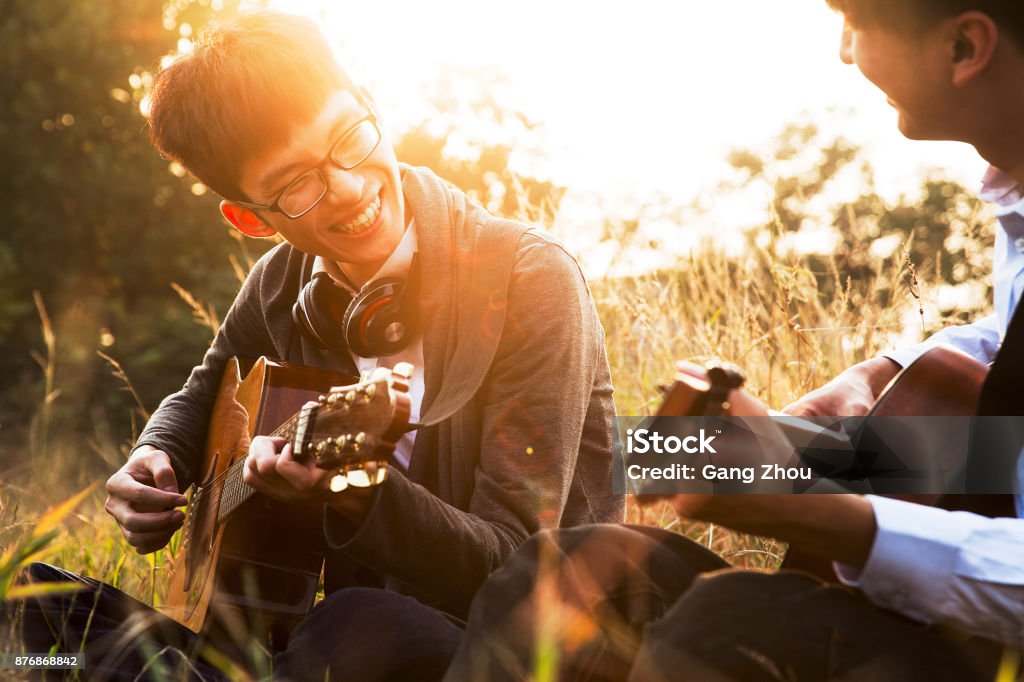 Two Menfriends Sitting On Lawn Playing Guitar Stock Photo - Download ... Two Menfriends Sitting On Lawn Playing Guitar Stock Photo - Download ...