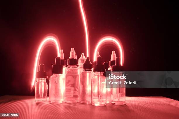 Vape 개념입니다 구름과 어두운 배경에 Vape 액체 병 연기 빛 효과입니다 Health에 대한 스톡 사진 및 기타 이미지