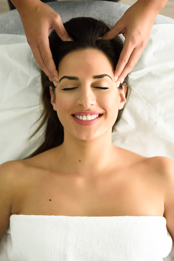 Young Smiling Woman Receiving A Head Massage In A Spa Center Stock