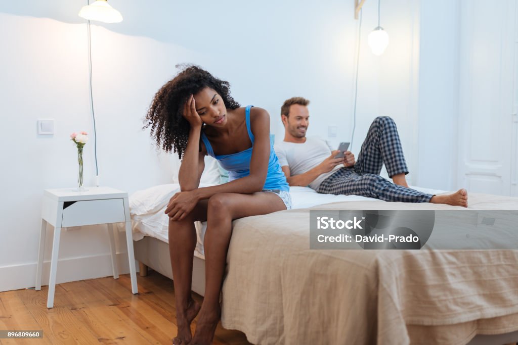 Young Beautiful Interracial Couple In Bed Stressed With Infidelity