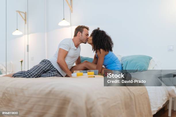 Young Beautiful Interracial Couple In Bed Giving A Surprise Breakfast