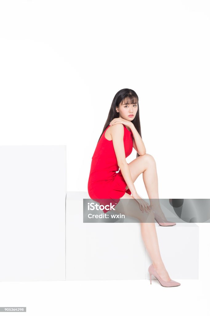 Attractive Asian Woman Wearing Red Dress Posing Over White Background