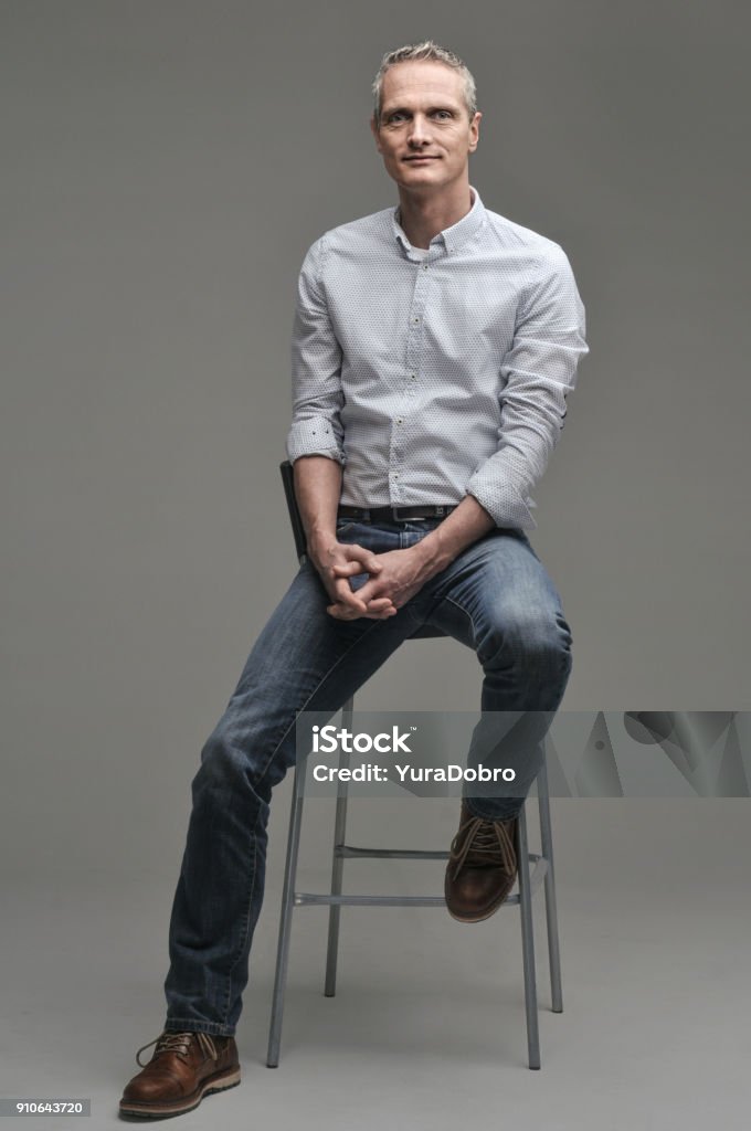 Pria Berbaju Kemeja Dan Celana Jeans Duduk Di Kursi Latar Belakang ... Pria Berbaju Kemeja Dan Celana Jeans Duduk Di Kursi Latar Belakang ...