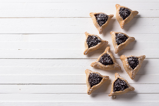 Hamantashen 쿠키 또는 귀 함 안의 양 귀 비 씨와 건포도 흰색 배경에 삼각형 쿠키 건포도에 대한 스톡 사진 및 기타