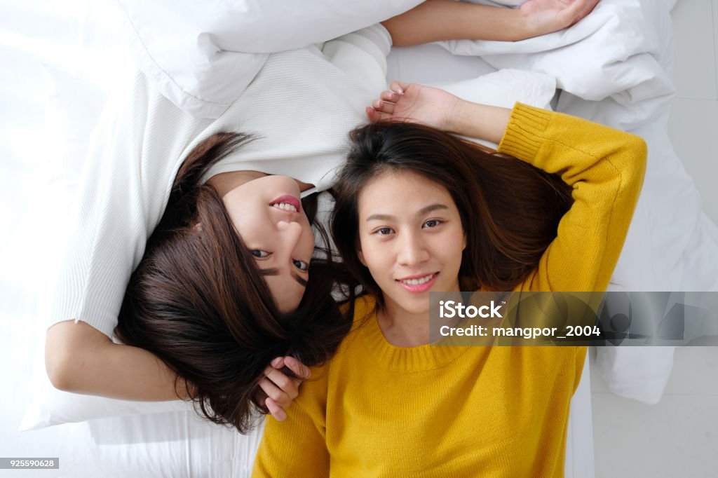 Lgbt Young Cute Asia Lesbians Lying And Smiling On White Bed Together