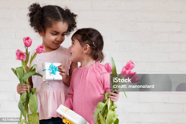 Dua Gadis Kecil Multietnis Memegang Hadiah Dan Tulip Untuk Hari Ibu ... Dua Gadis Kecil Multietnis Memegang Hadiah Dan Tulip Untuk Hari Ibu ...