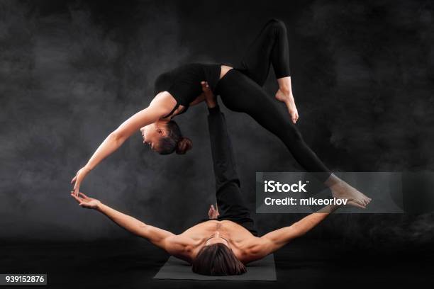 Acroyoga입니다 젊은 커플 함께 Acro 요가 스튜디오에 매트에 연습 커플의 요가 파트너의 요가 흑인과 백인 사진입니다