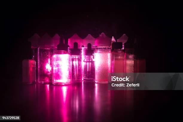 Vape 개념입니다 구름과 어두운 배경에 Vape 액체 병 연기 조명 효과 0명에 대한 스톡 사진 및 기타 이미지 0명