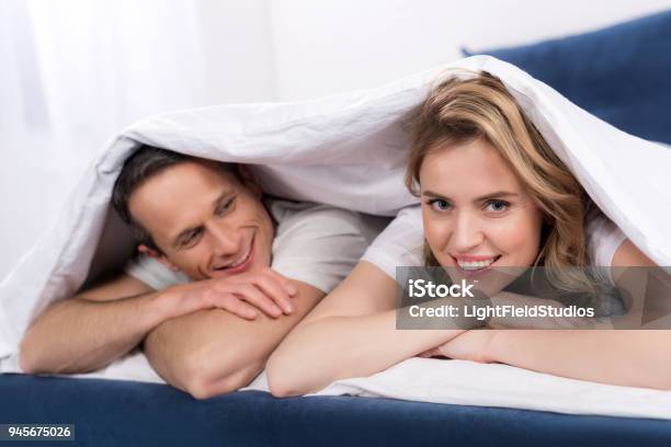 Potret Istri Dan Suami Tersenyum Di Bawah Selimut Berbaring Di Tempat ... Potret Istri Dan Suami Tersenyum Di Bawah Selimut Berbaring Di Tempat ...