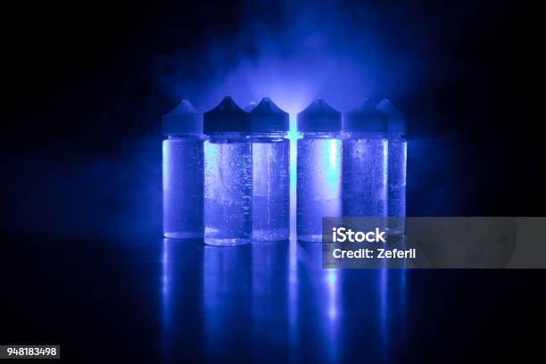 Vape 개념입니다 구름과 어두운 배경에 Vape 액체 병 연기 조명 효과 0명에 대한 스톡 사진 및 기타 이미지 0명
