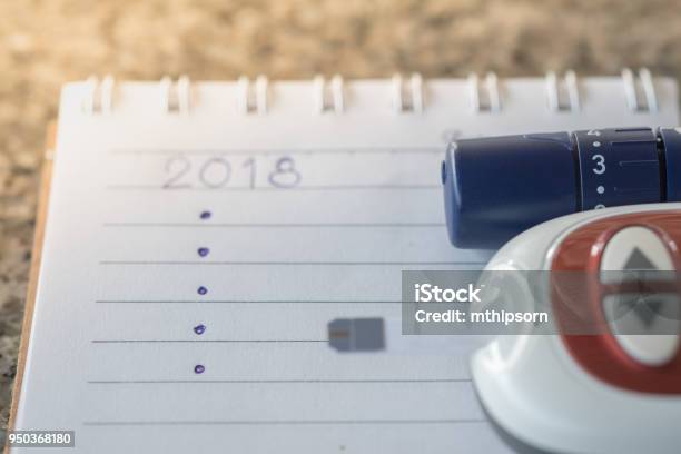 2018 건강 관리 의학 당뇨병 개념입니다 첨 두 및 포도 당 측정기 손으로 번호를 쓰는 노트북에 혈액 설탕 수준을 확인 합니다