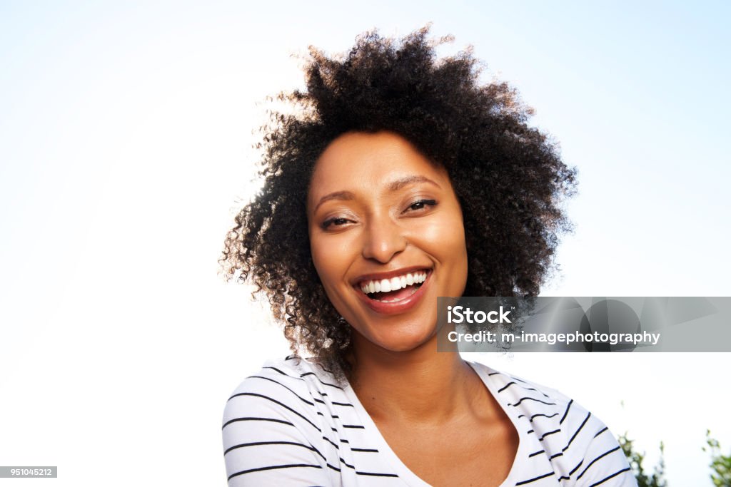Close Up Happy Young Black Woman Laughing Outdoors Against Bright