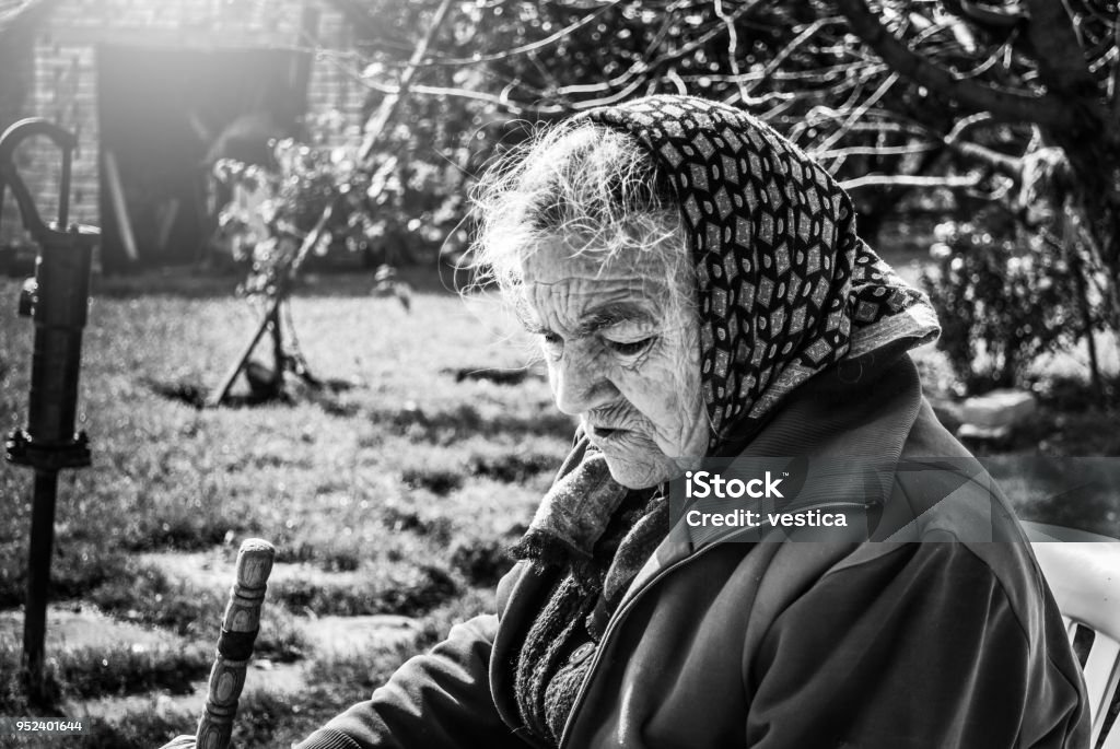 Photo Libre De Droit De Vieille Dame Avec Un Visage Ridé Est Assis Sur