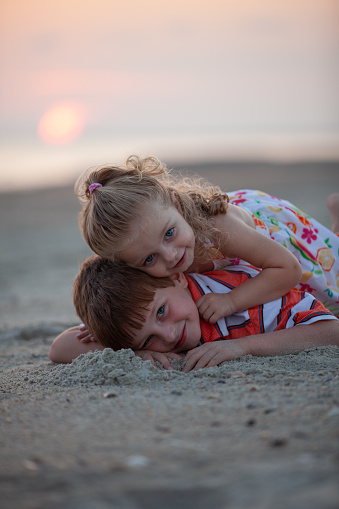 Portrait Young Brother And Sister Smile And Pose Together On The Beach