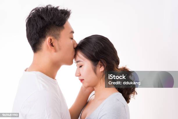 A Man Kissing His Womans Head With Love And Affection The Woman Is