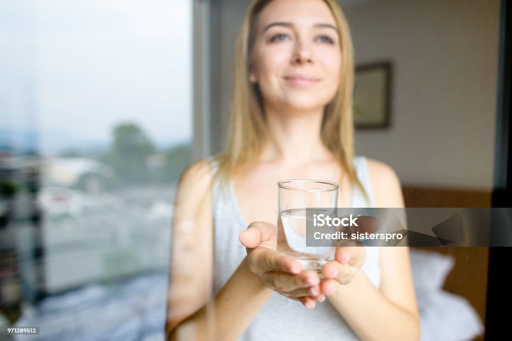 Young Beautiful Woman Drinking Glass Of Water At Hotel In Morning Stock