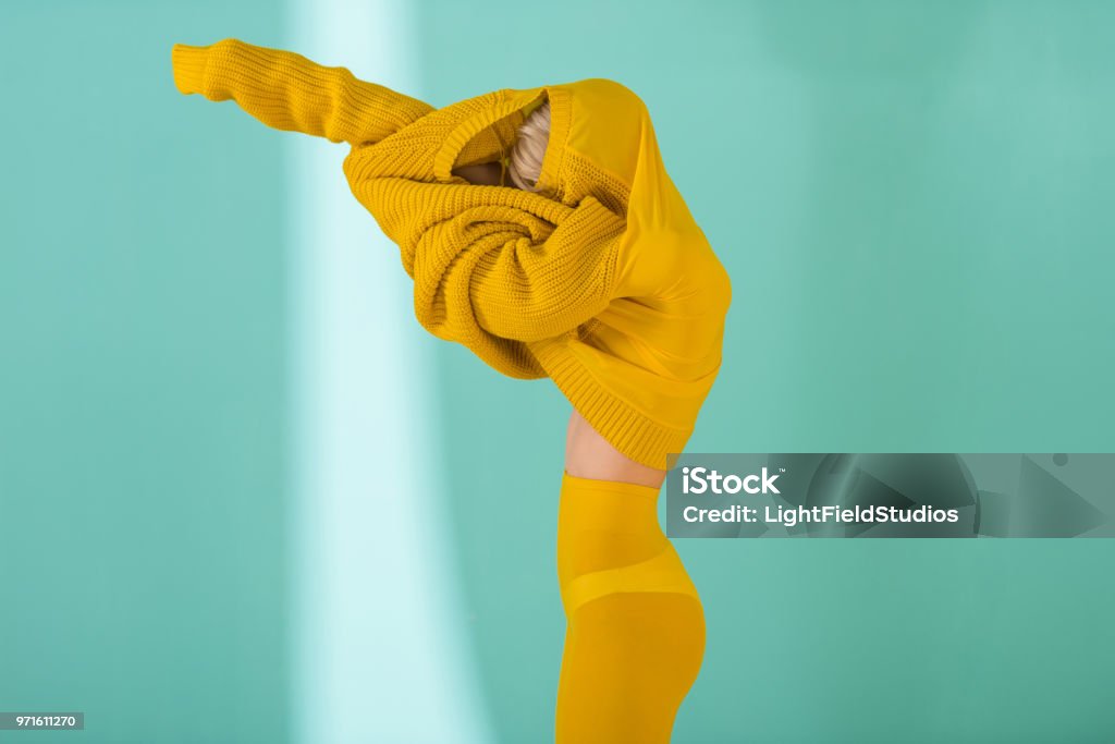 Side View Of Woman In Yellow Tights Wearing Yellow Sweater Posing On