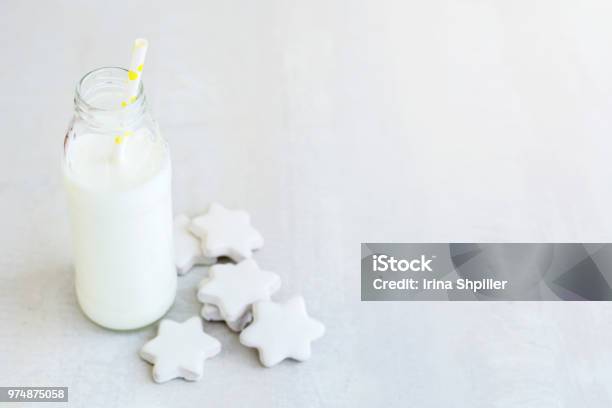 Sebotol Susu Dan Kue Berbentuk Bintang Di Atas Meja Kayu Putih Foto