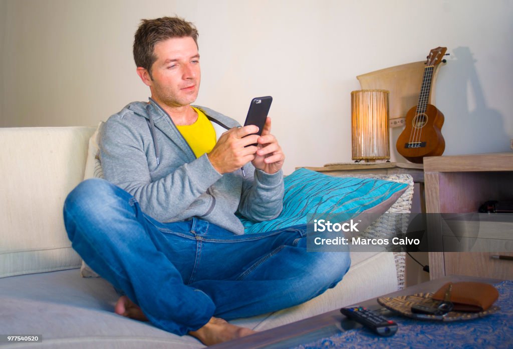 Young Cool Attractive And Happy Man Sitting At Living Room Sofa Couch