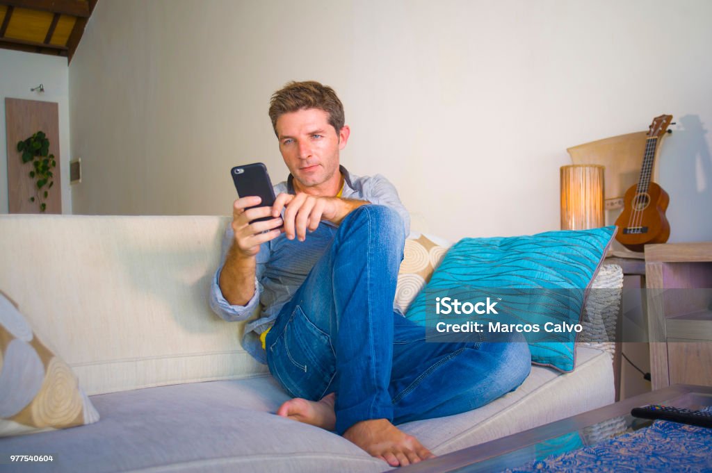 Young Cool Attractive And Happy Man Sitting At Living Room Sofa Couch