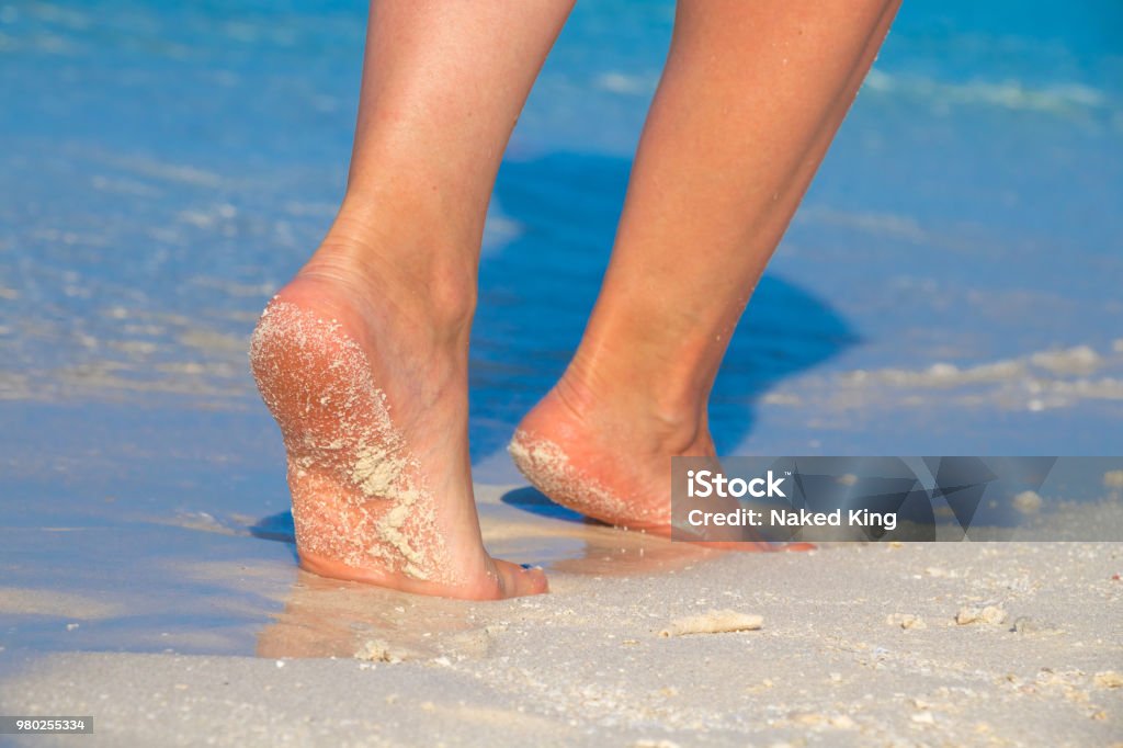 Crispy Tanned Women Legs On The Beach With Sandy Soles On The Sandy