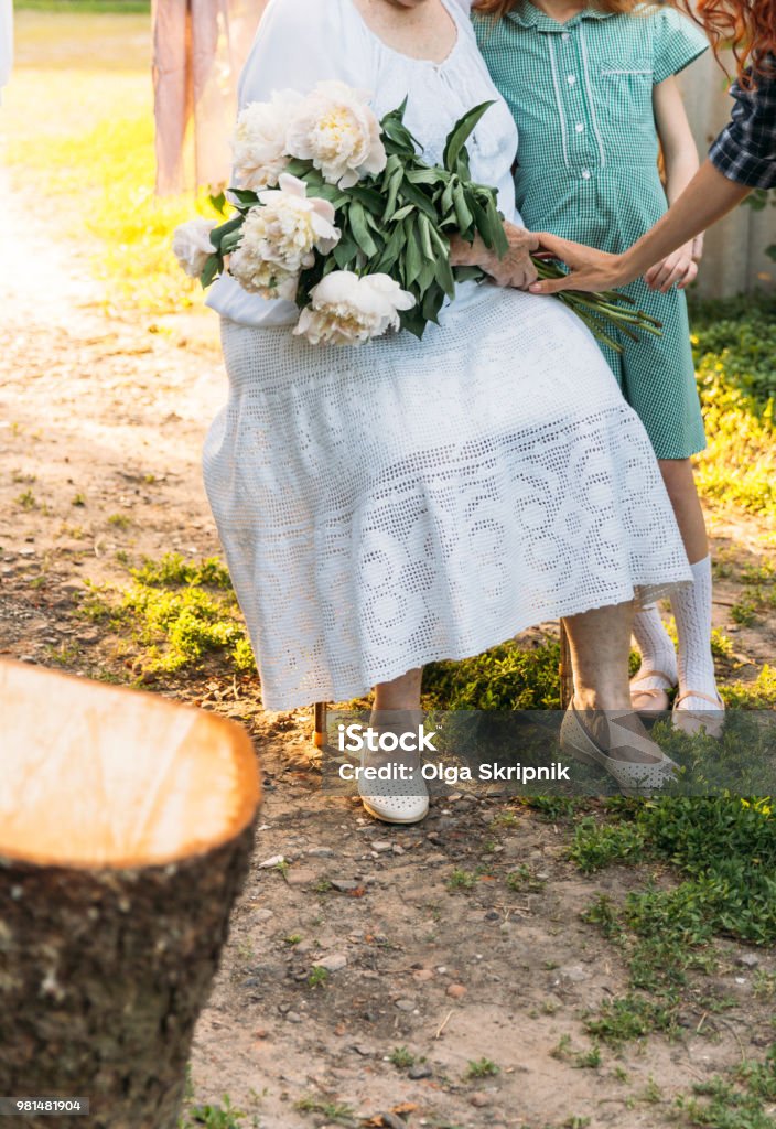 Grandmother Elderly Woman Sitting And Hugging Her Granddaughter Girl