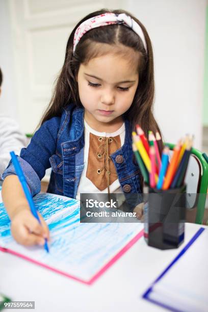 Gadis Kecil Menggambar Dengan Pensil Berwarna Dalam Buku Foto Stok
