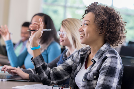 Confident Female College Students Raise Hands In Class Stock Photo ... Confident Female College Students Raise Hands In Class Stock Photo ...